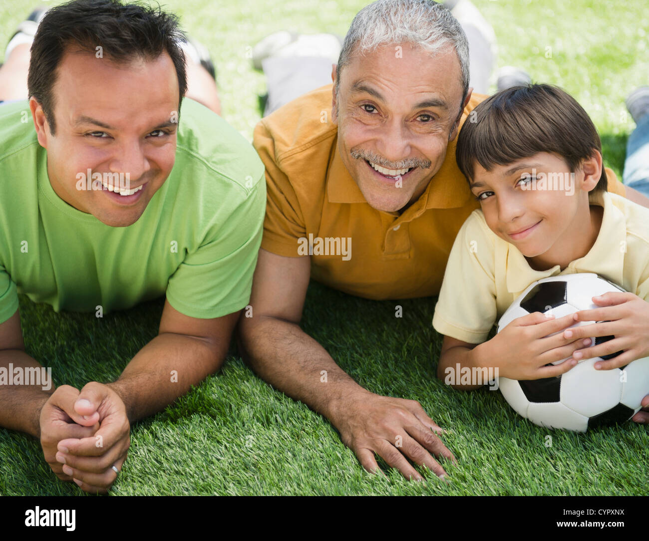 Hispanic grandfather, father and son laying in grass Stock Photo - Alamy