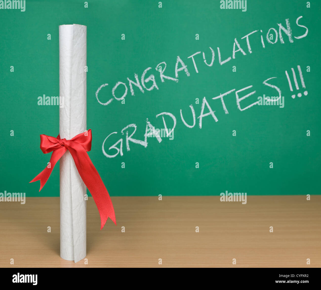 Congratulations graduates written on a chalkboard with a diploma on ...