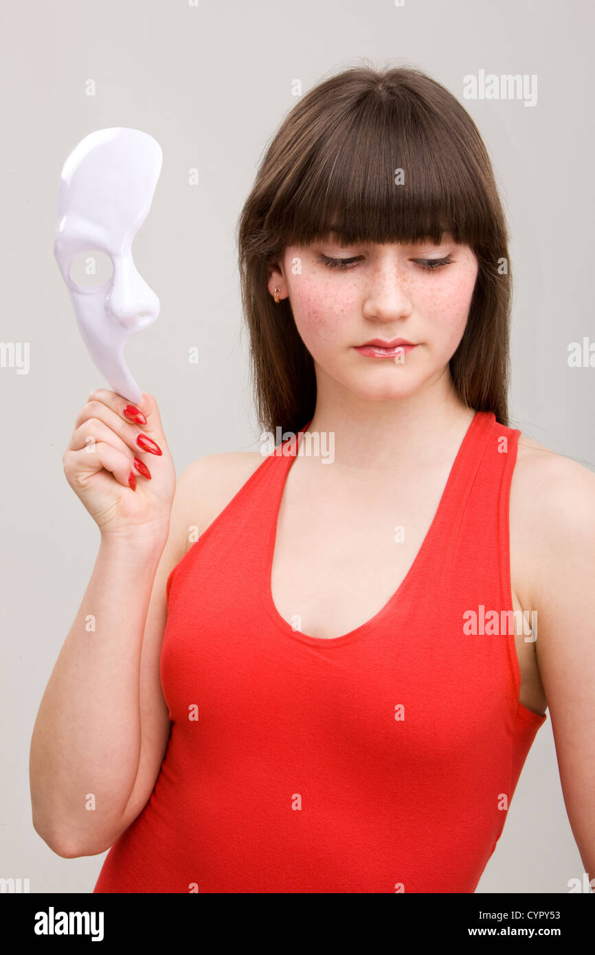 Portrait of a young girl holding half face mask Stock Photo - Alamy