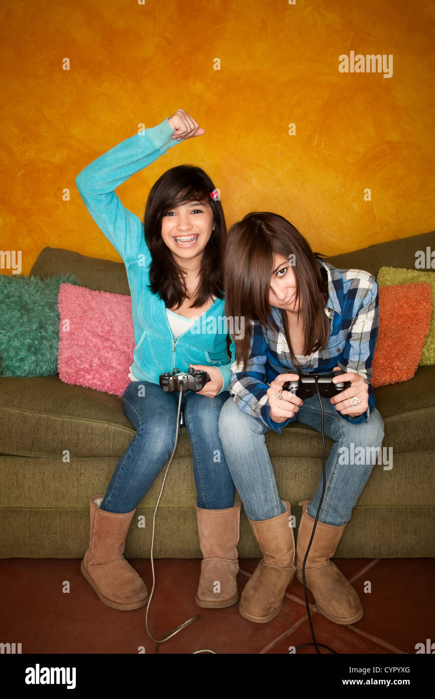 Cute Hispanic Girls Playing a Video Game with Handheld Controllers ...