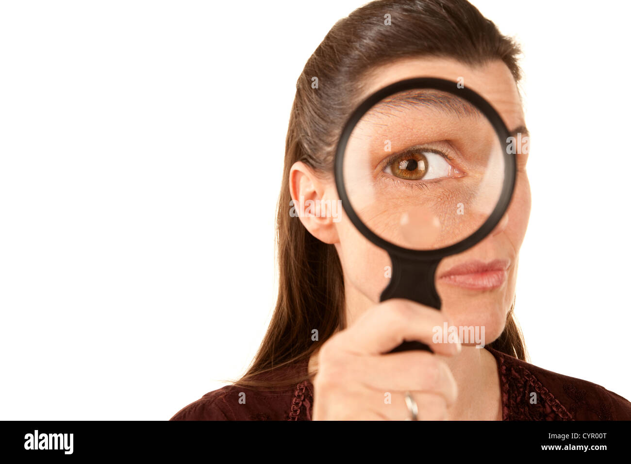 Pretty adult woman looking through magnifying glass Stock Photo - Alamy