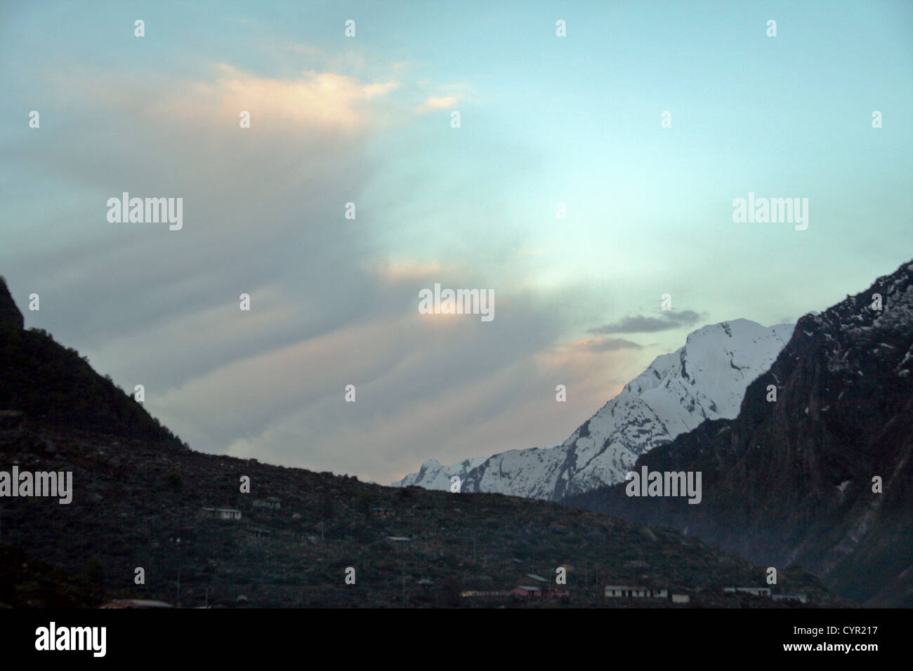 Faint clouds floating behind dark mountain peaks Stock Photo - Alamy