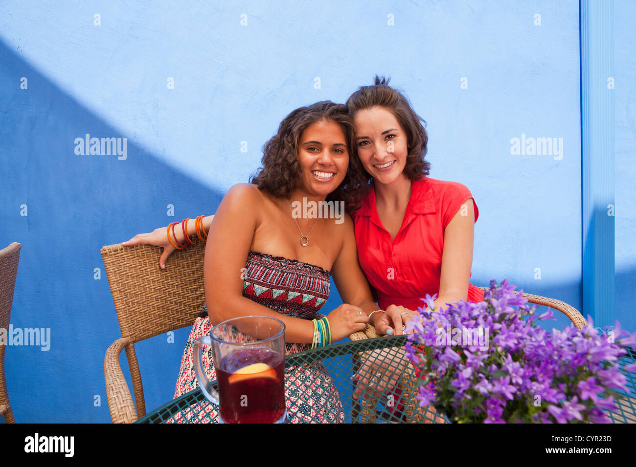 Friends sitting at patio table together Stock Photo - Alamy