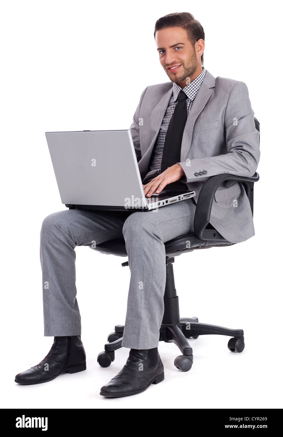 Business man sitting with laptop and smiling at office desk isolated ...