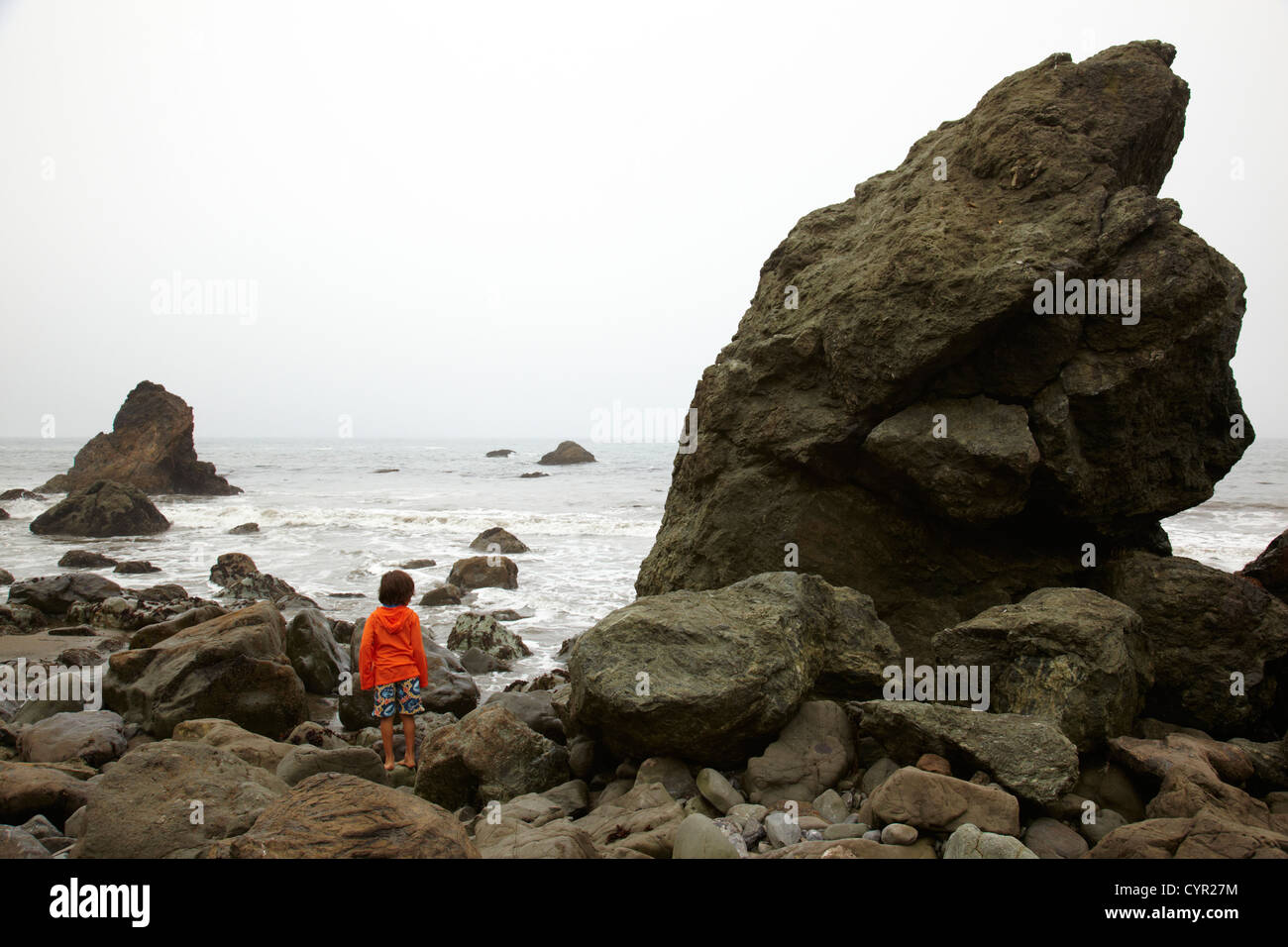Boy standing near rocks hi-res stock photography and images - Alamy