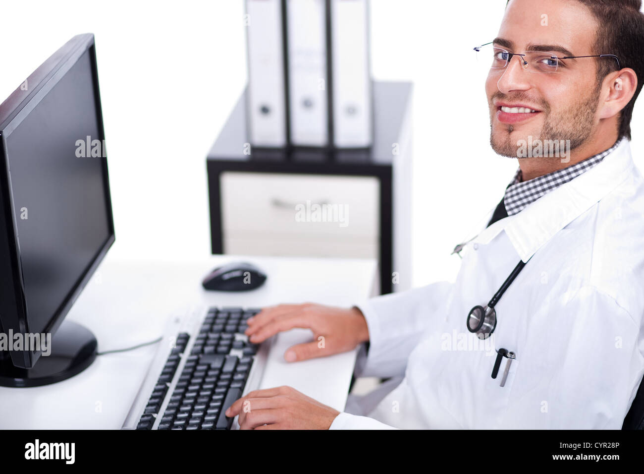 Smiling young doctor working on his desk over a white background Stock ...
