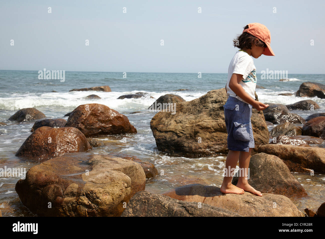 Boy standing near rocks hi-res stock photography and images - Alamy