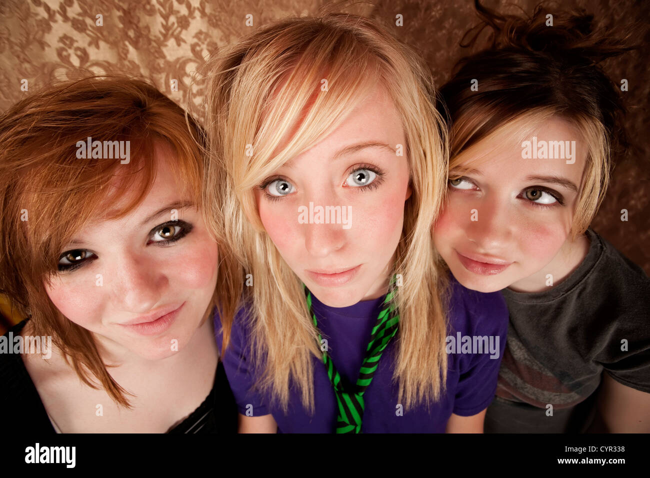 Portrait of three pretty young girls on a gold background Stock Photo ...