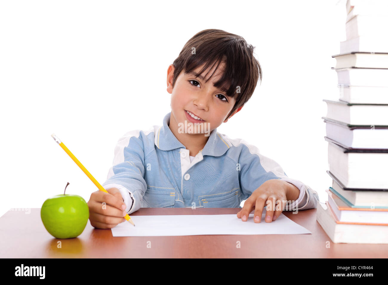 School boy doing his homework with an apple beside him on white ...