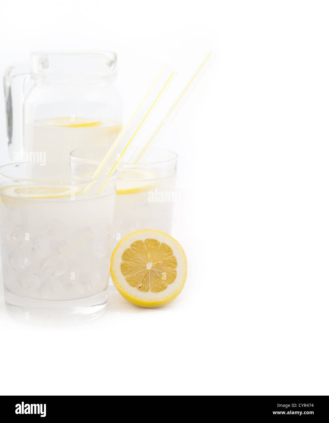 fresh lemonade drink with lemon slice closeup and pitcher carafe ...