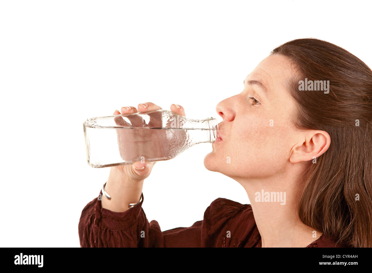Pretty adult woman drinking water from a glass bottle Stock Photo - Alamy