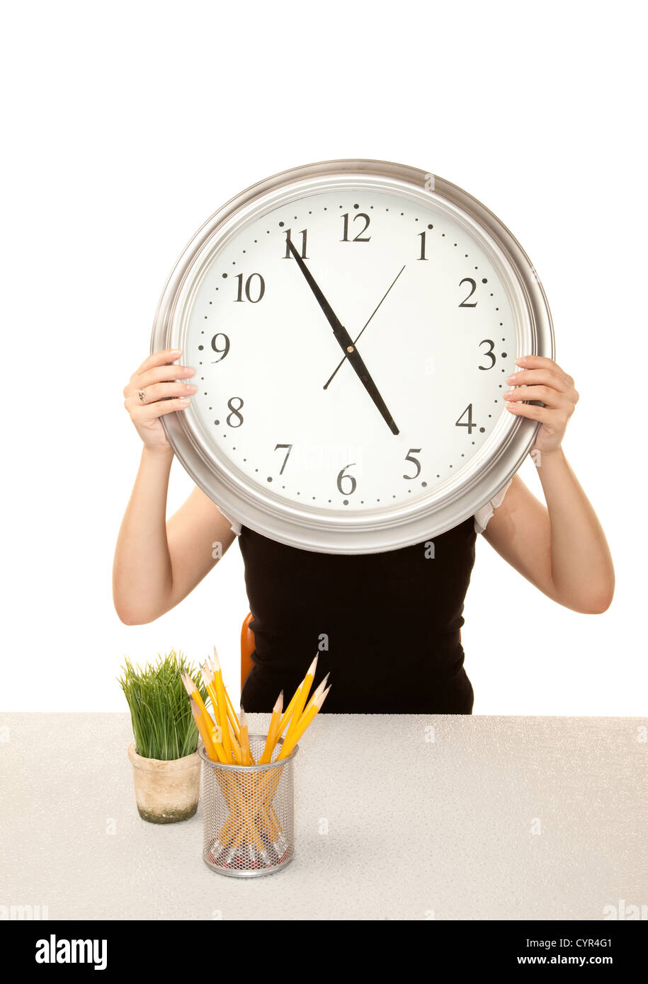 Woman at work holding up large office clock Stock Photo - Alamy