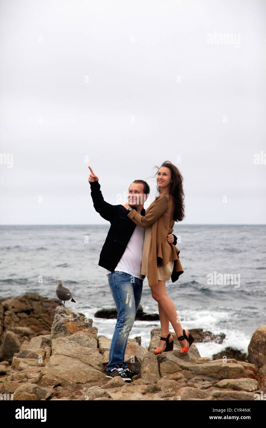 Beautiful young pair in the foggy morning on a coast in Half Moon Bay ...