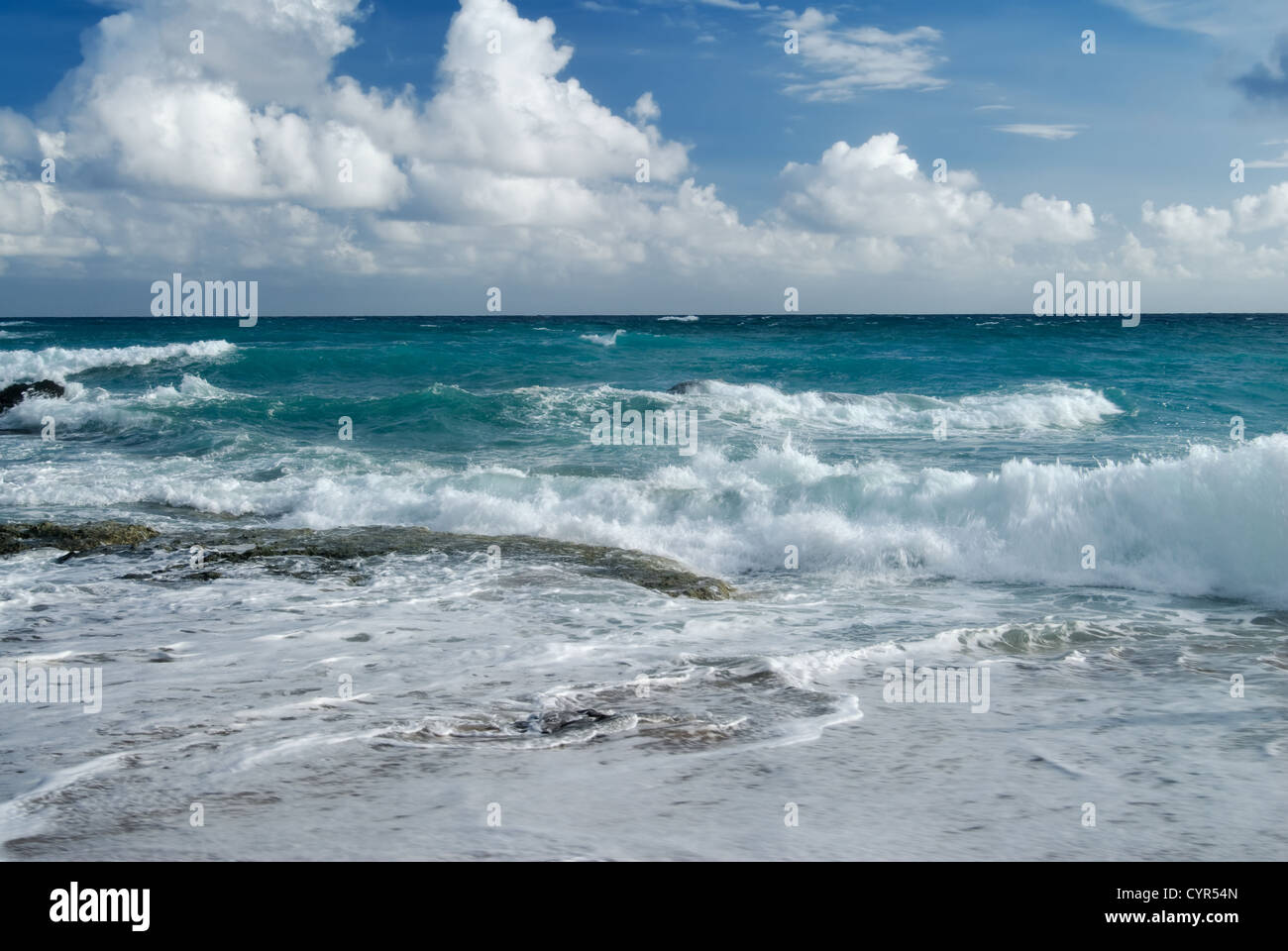 Beach with dramatic sea wave under blue sunny sky Stock Photo - Alamy