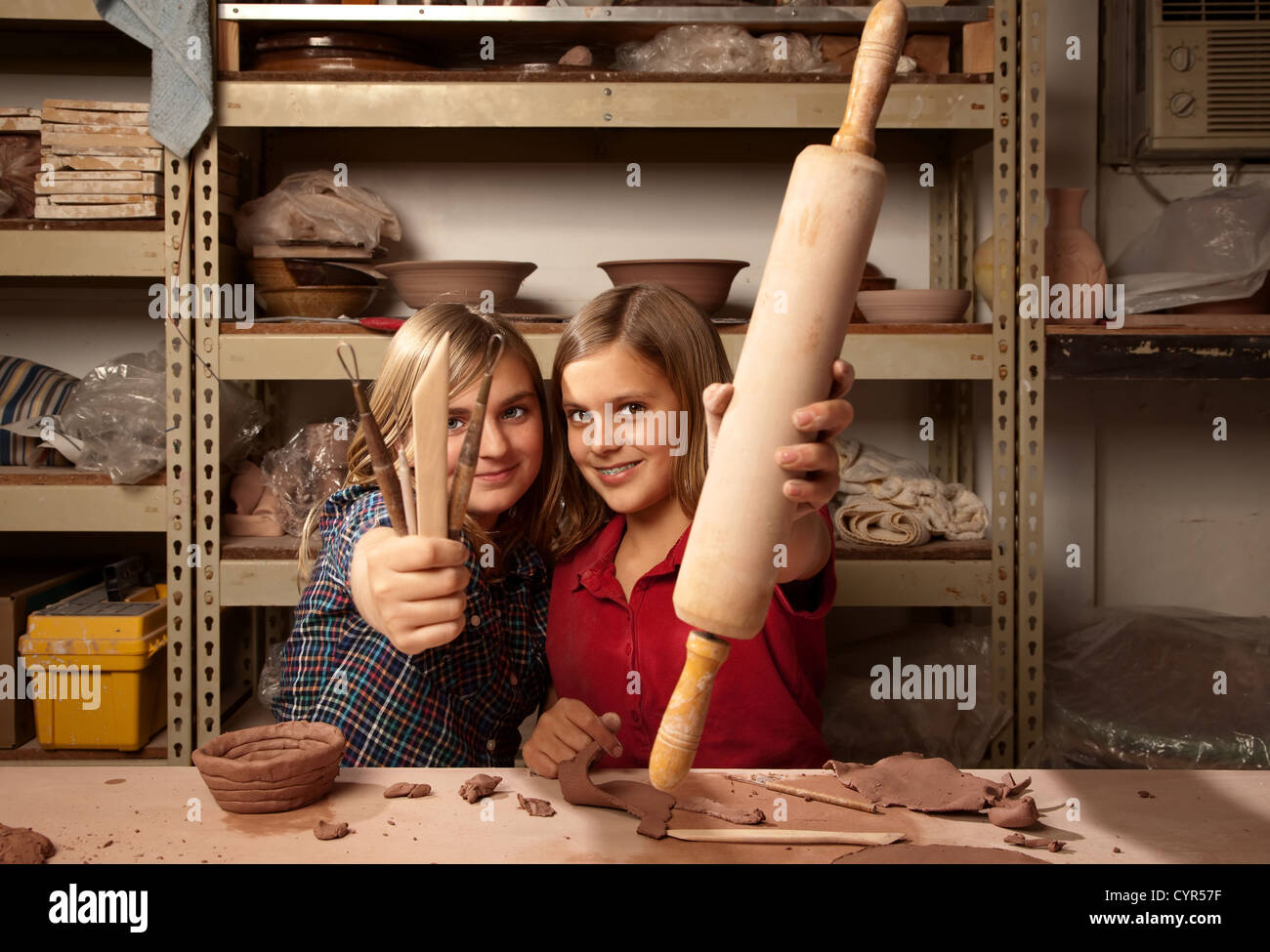 Young girls holding craft tools in clay studio Stock Photo - Alamy