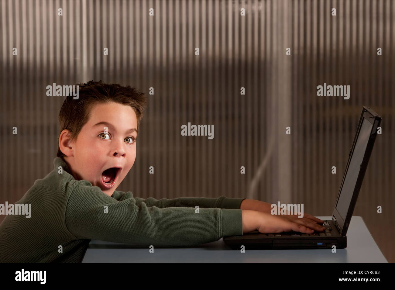Shocked young boy reacting to info on a laptop computer Stock Photo - Alamy