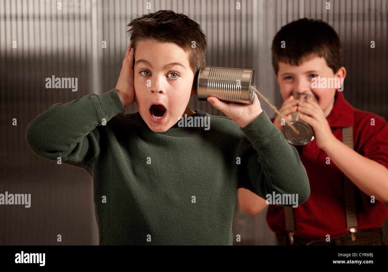 Little boy getting shocking message from friend on tin can phone Stock ...