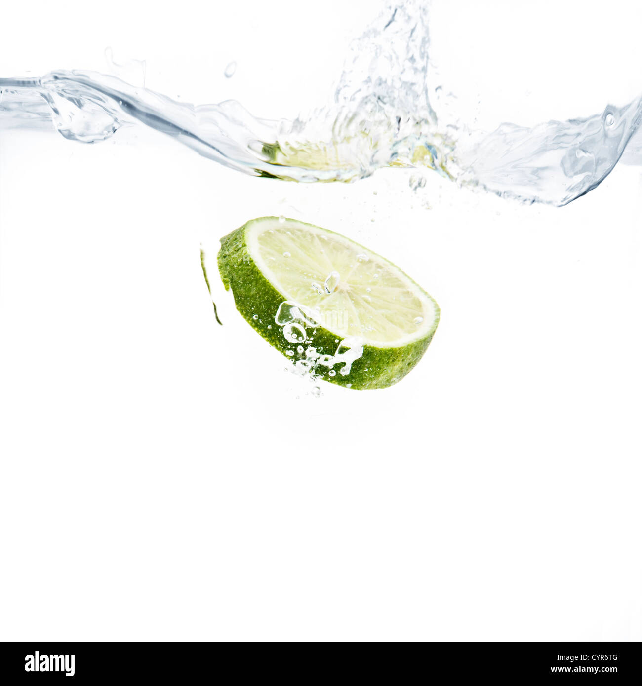 lime slice splashing into water with white background Stock Photo - Alamy