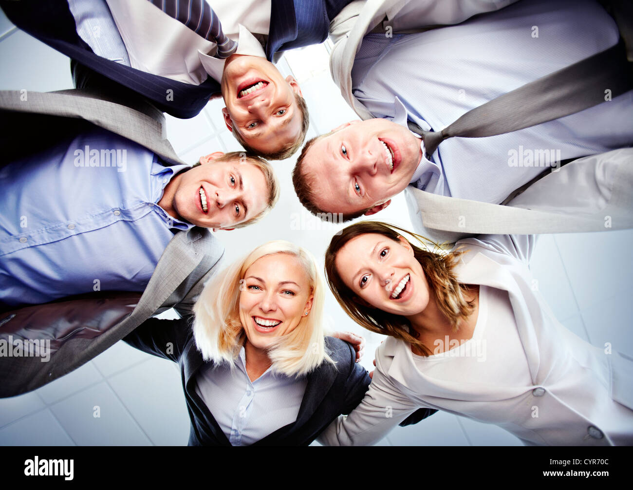 Below view of several happy business partners looking at camera while ...