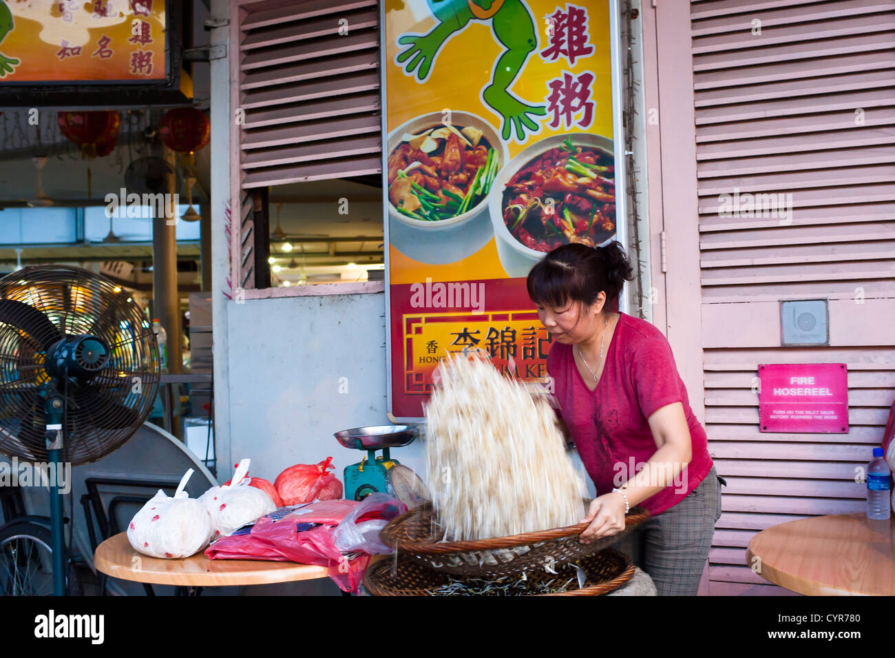 Woman tossing noodles, Singapore Stock Photo - Alamy
