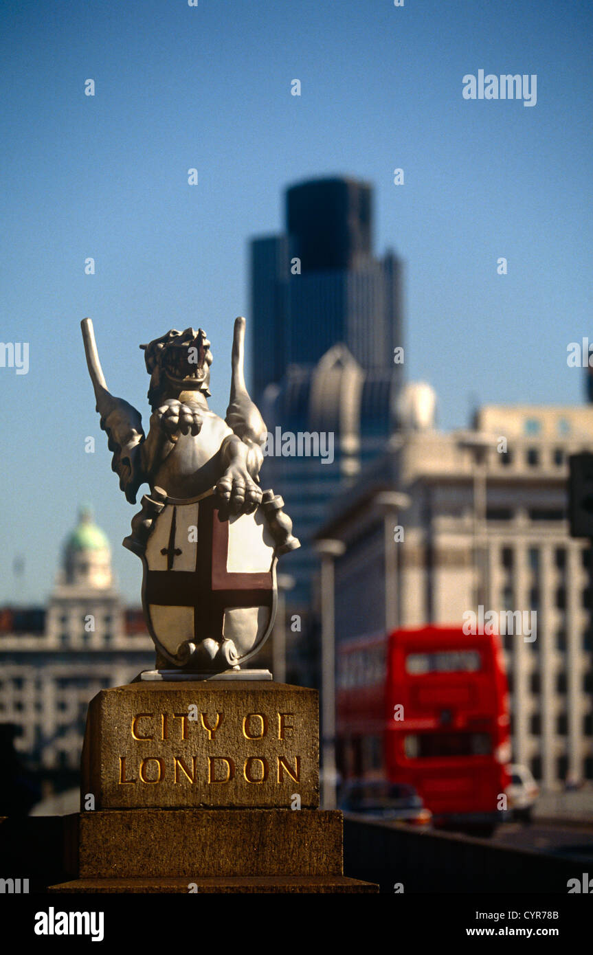 Bus drives over London Bridge, a griffin statue marks the southern ...