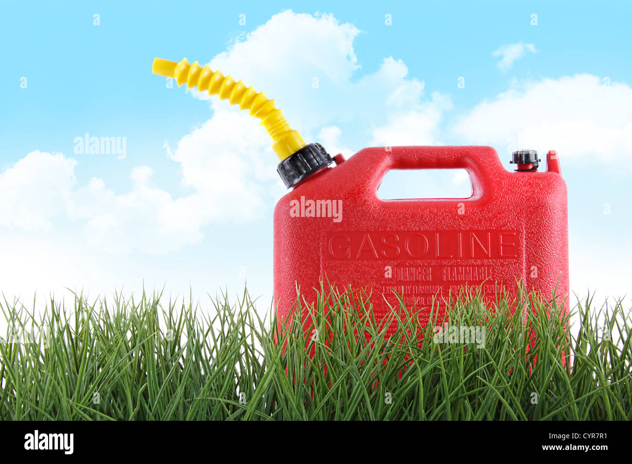 Plastic gas can in grass against white background Stock Photo - Alamy