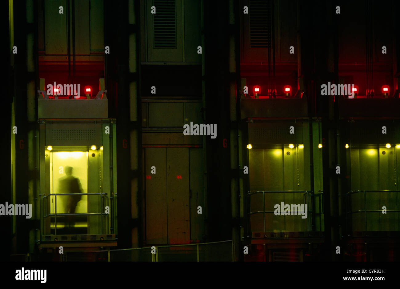 A blurred figure exits a lift (elevator) at night after having ...
