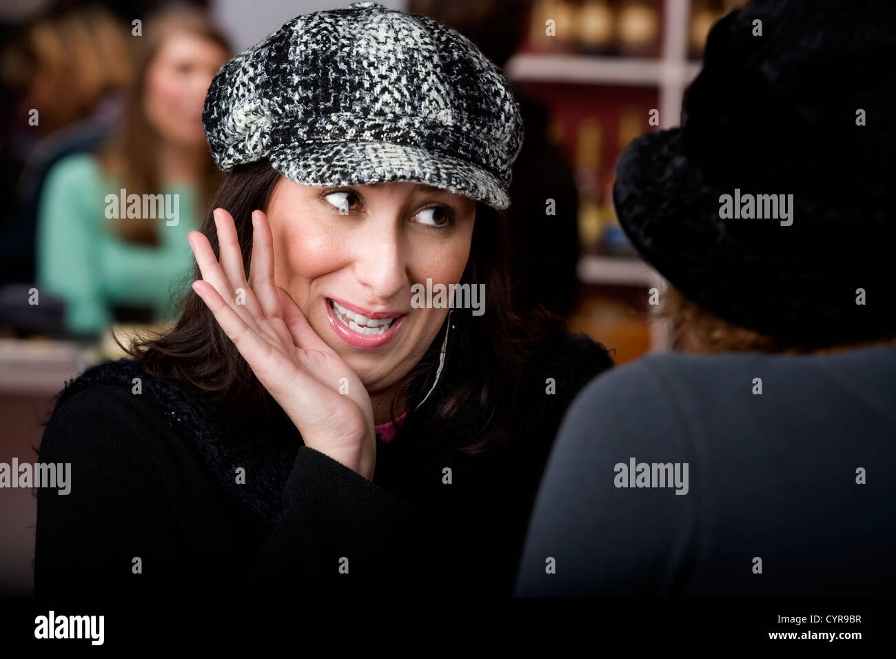 Pretty Hispanic woman with coffee sharing gossip Stock Photo - Alamy