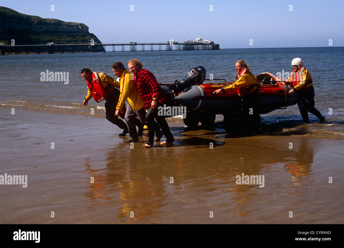 Volunteer RNLI lifeboatmen bring ashore one of their inflatable ...