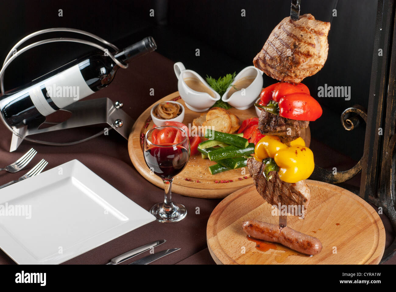 Big tasty roasted meat cuts at skewer on a decorated table Stock Photo ...