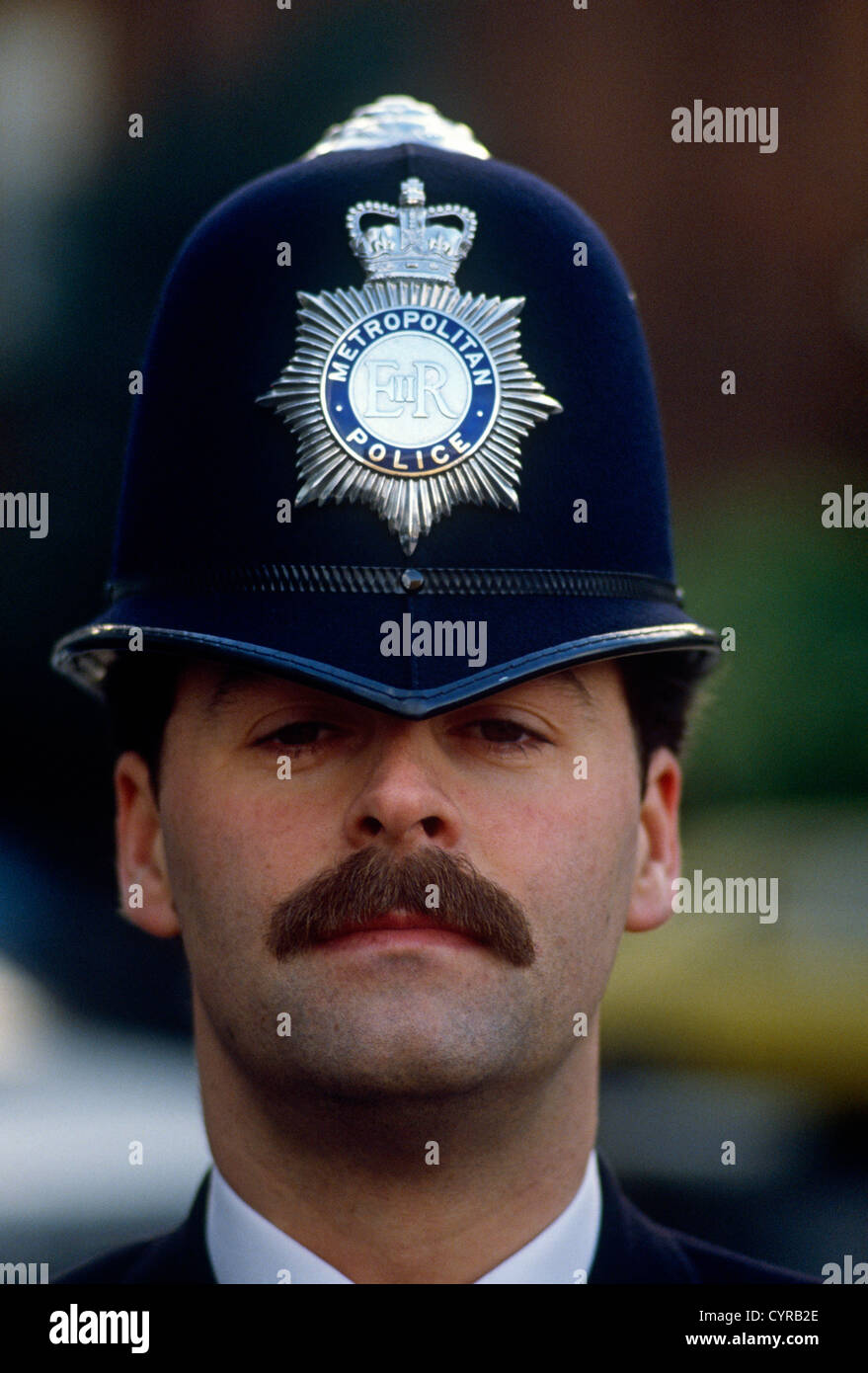 A close-up detail of a London Metropolitan police officer's face and ...