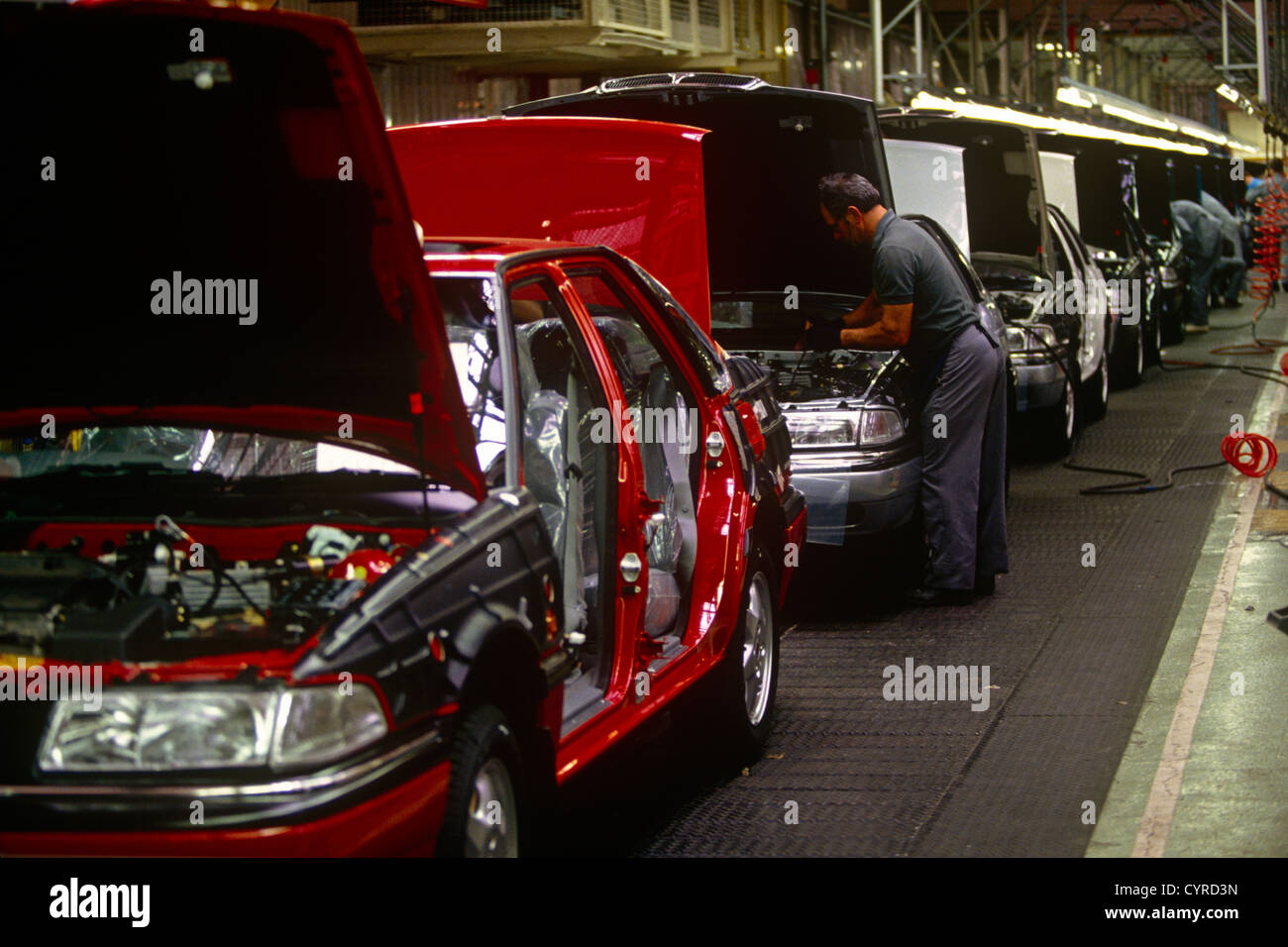 A car worker fits engines on the production line in the German BMW ...