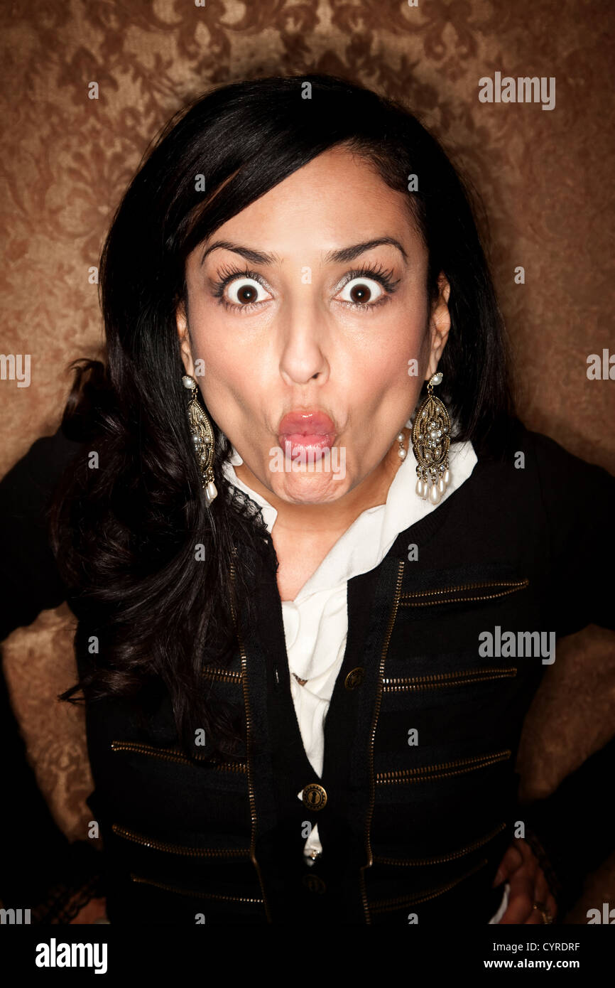 Pretty Hispanic Woman on Gold Background Making a Funny Face Stock ...