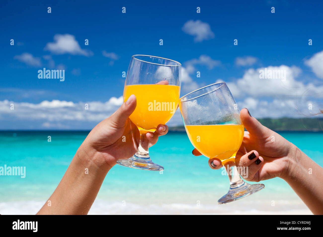 Cocktails on beach in female hands, cheers Stock Photo - Alamy