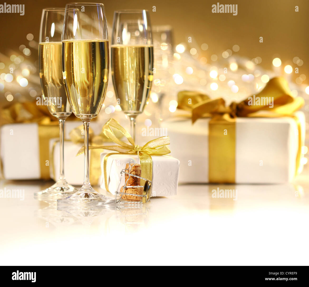 Glasses of champagne with gold ribboned gifts Stock Photo - Alamy