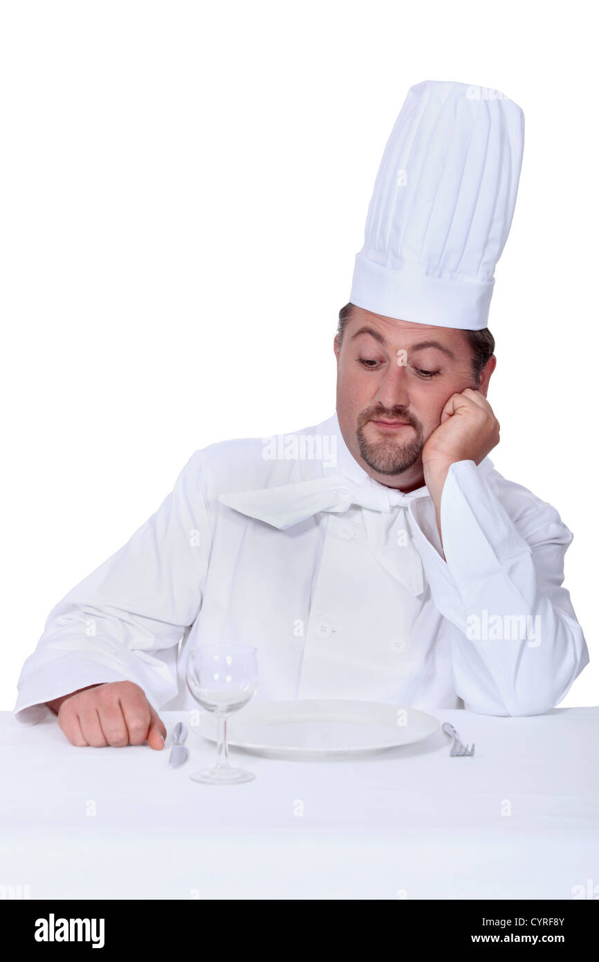 Chef looking disdainfully at an empty plate Stock Photo - Alamy