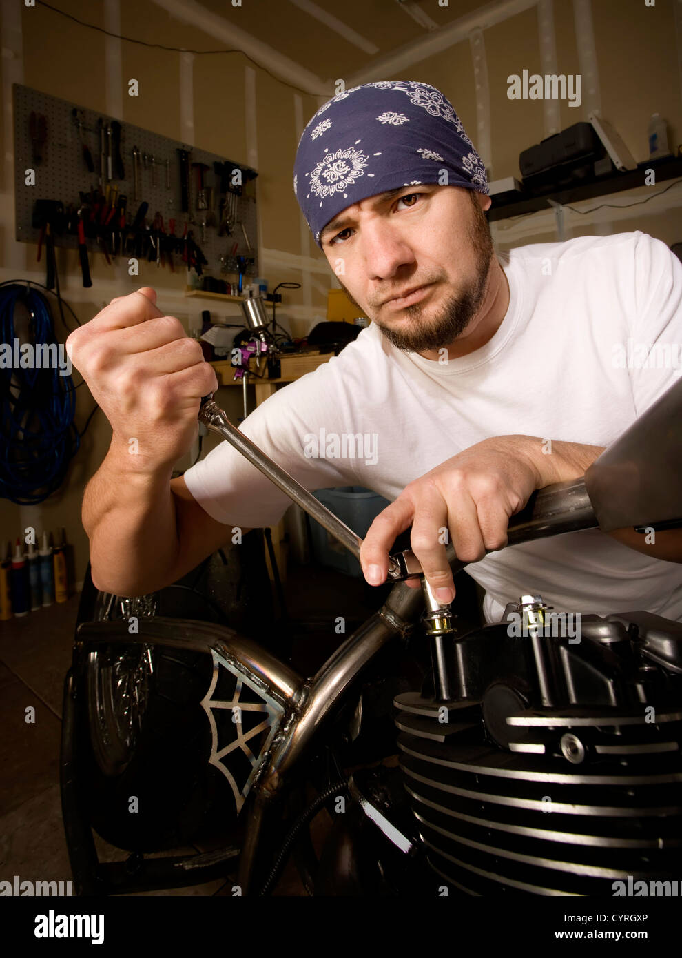 Hispanic mechanic working on a chopper style motorcycle Stock Photo - Alamy