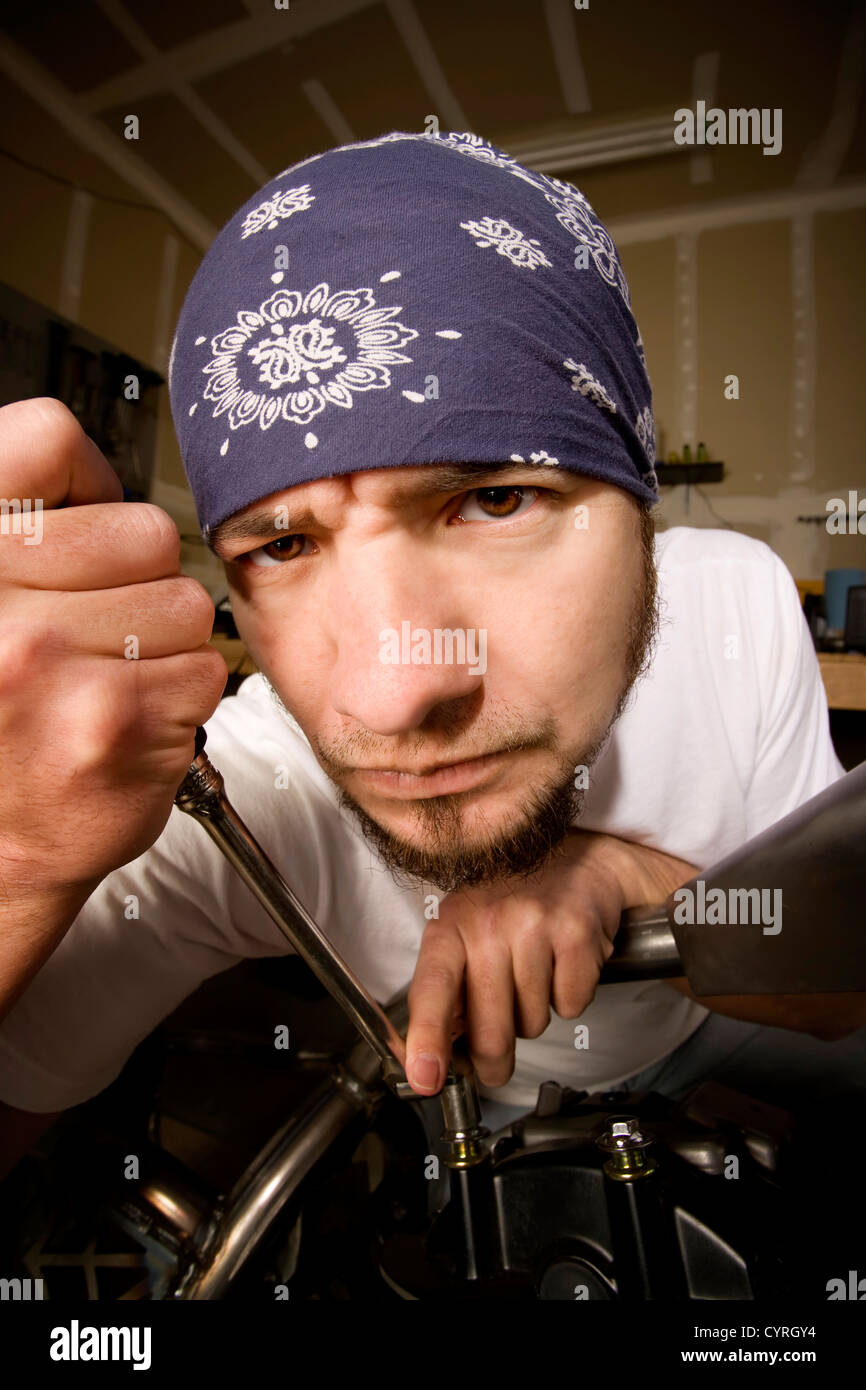 Hispanic mechanic working on a chopper style motorcycle Stock Photo - Alamy