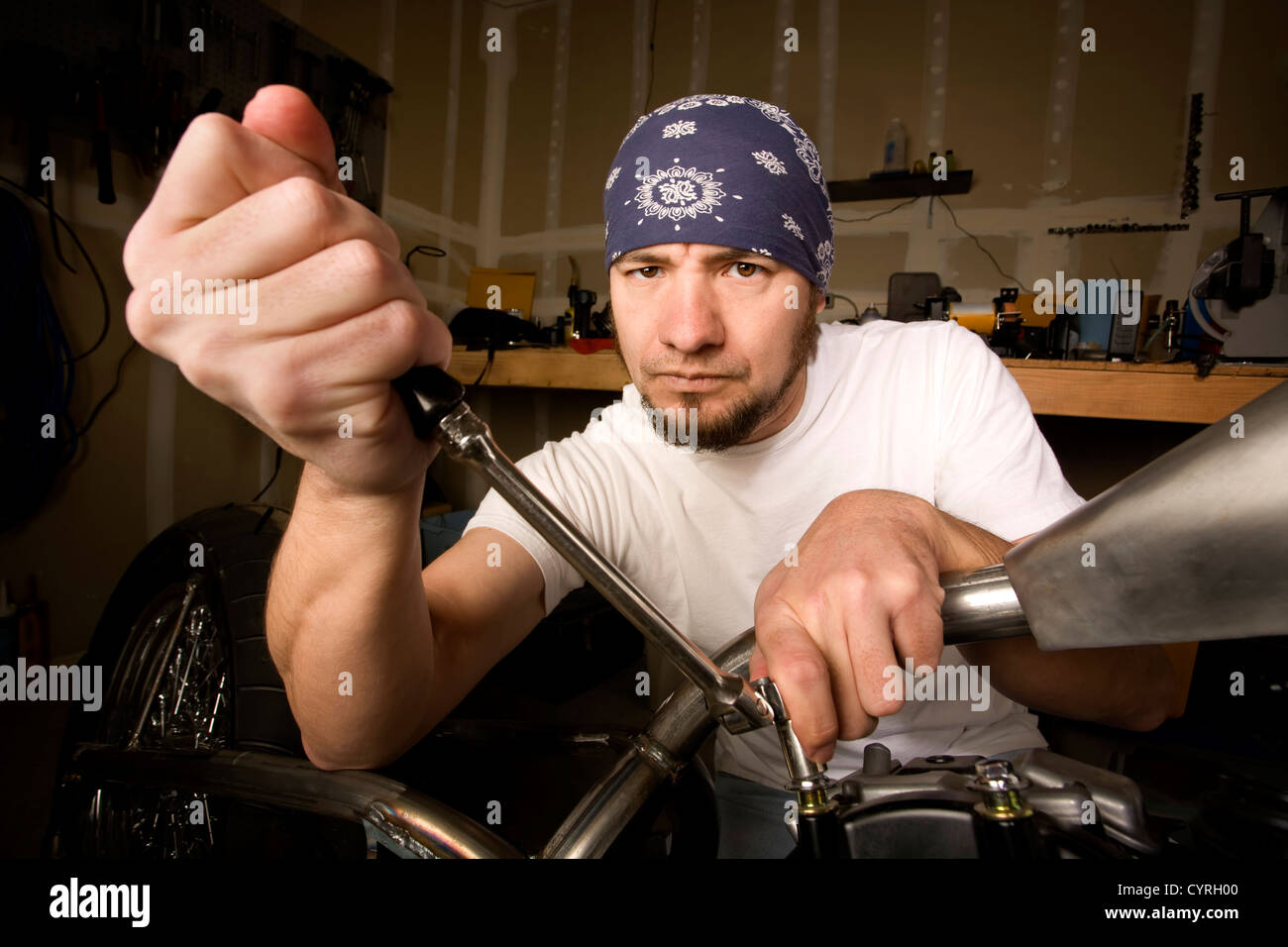Hispanic mechanic working on a chopper style motorcycle Stock Photo - Alamy