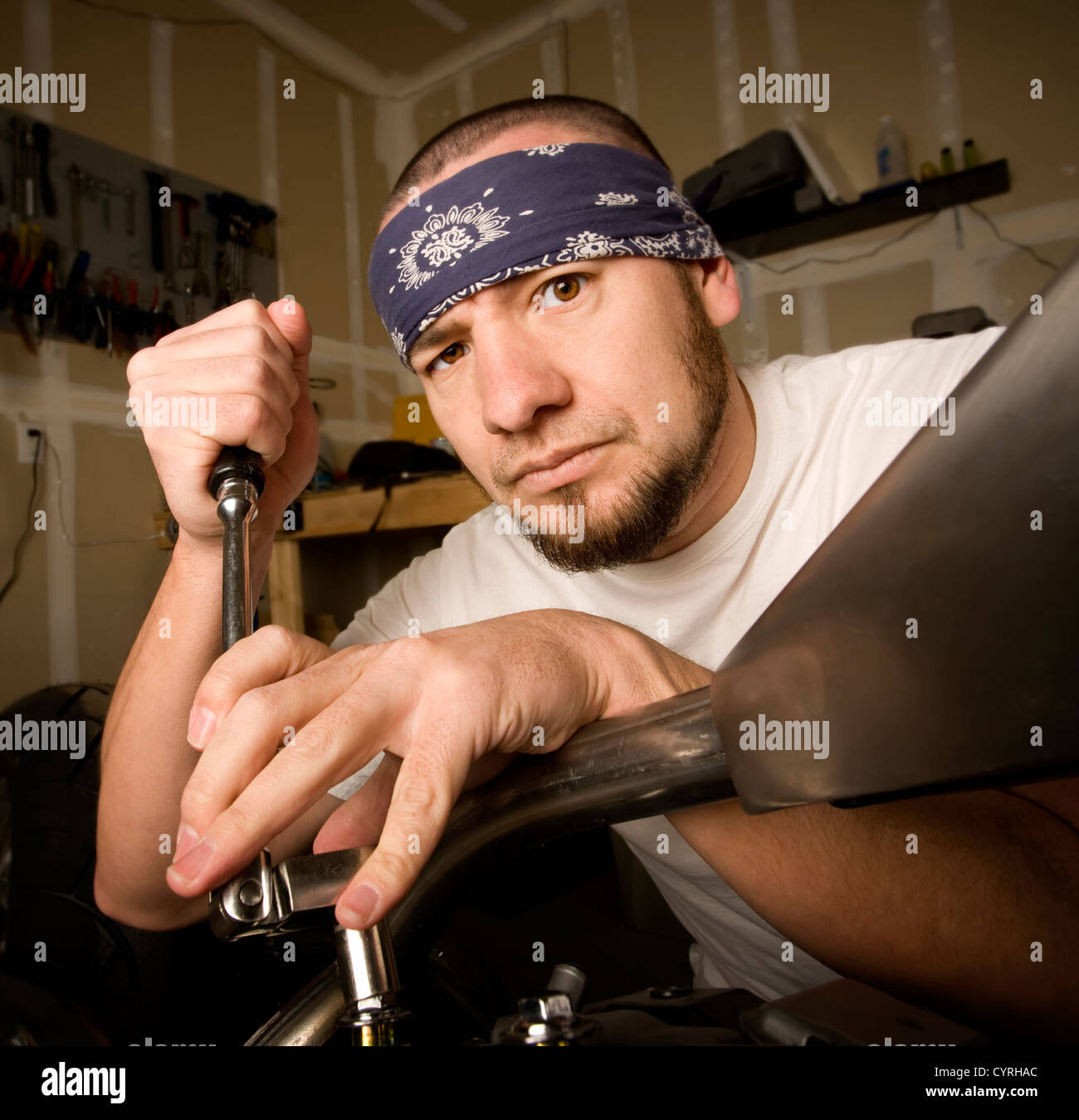 Hispanic mechanic working on a chopper style motorcycle Stock Photo - Alamy