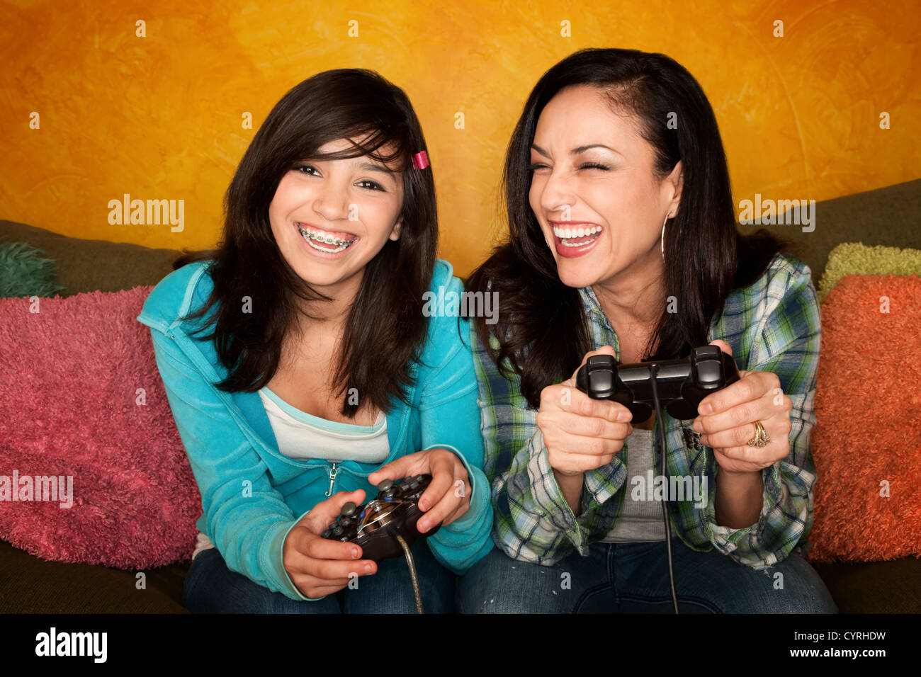 Attractive Hispanic Woman and Girl Playing a Video Game with Handheld ...