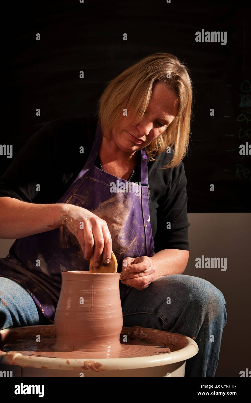 Female potter at wheel in studio shaping clay Stock Photo - Alamy