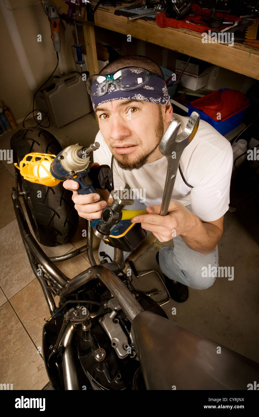 Hispanic mechanic working on a chopper style motorcycle Stock Photo - Alamy