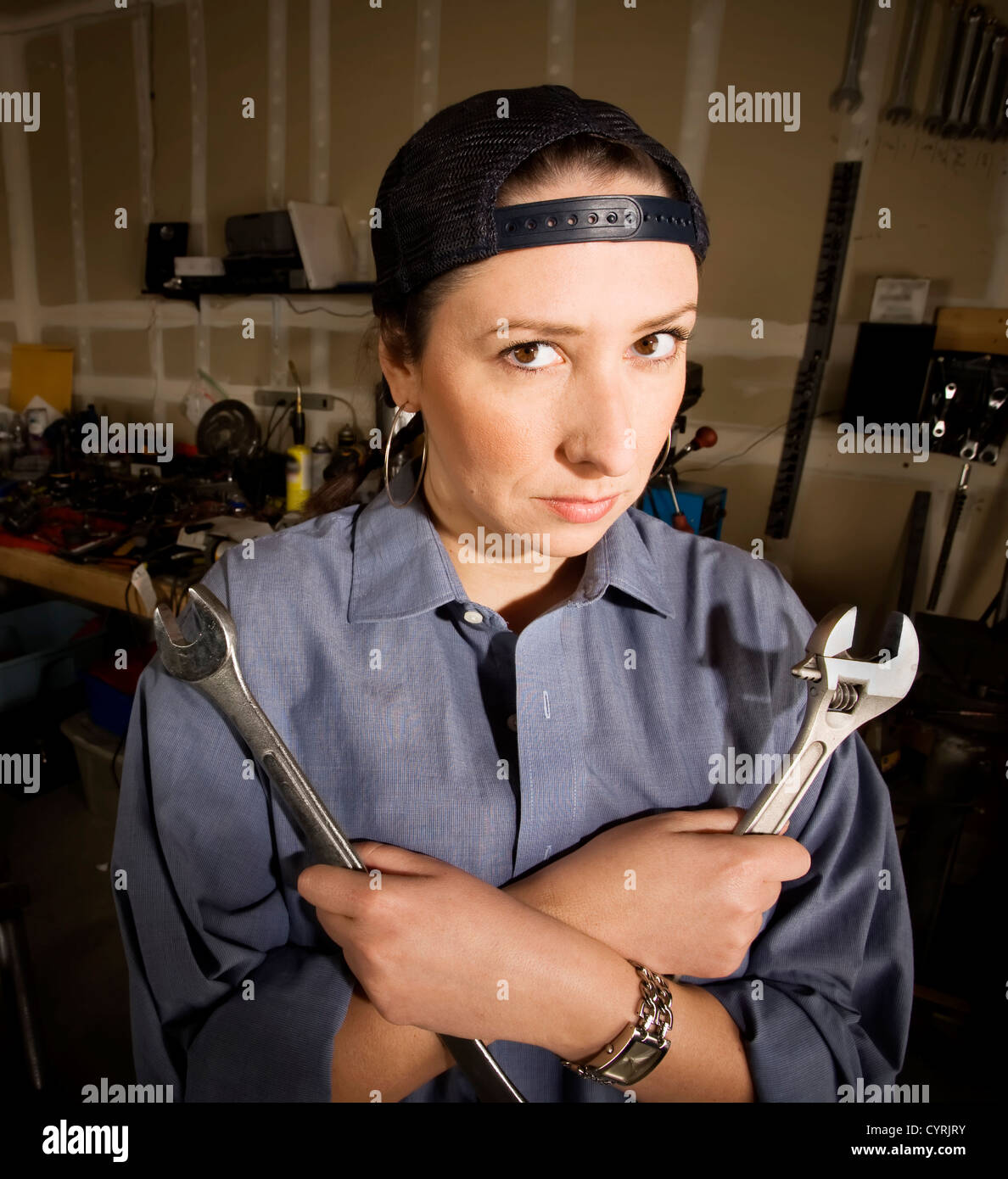 Hispanic woman in a garage with wrenches Stock Photo - Alamy