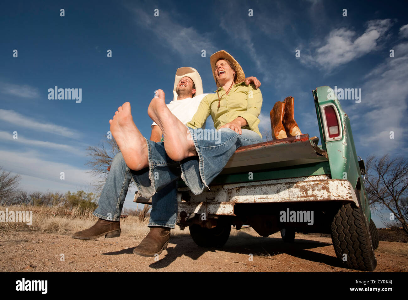 Portrait of Cowboy and woman on pickup truck bed Stock Photo - Alamy