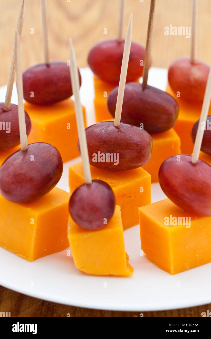 Perfect party snacks. Cheese cubes with red seedless grapes on a plate ...