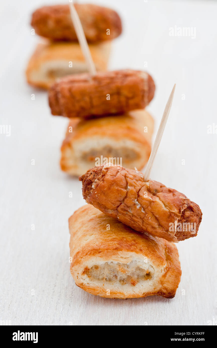 Perfect party snacks. A line of mini sausage rolls with cocktail ...