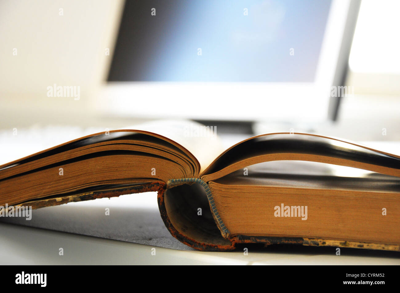 old books and computer on a desk in a library Stock Photo - Alamy