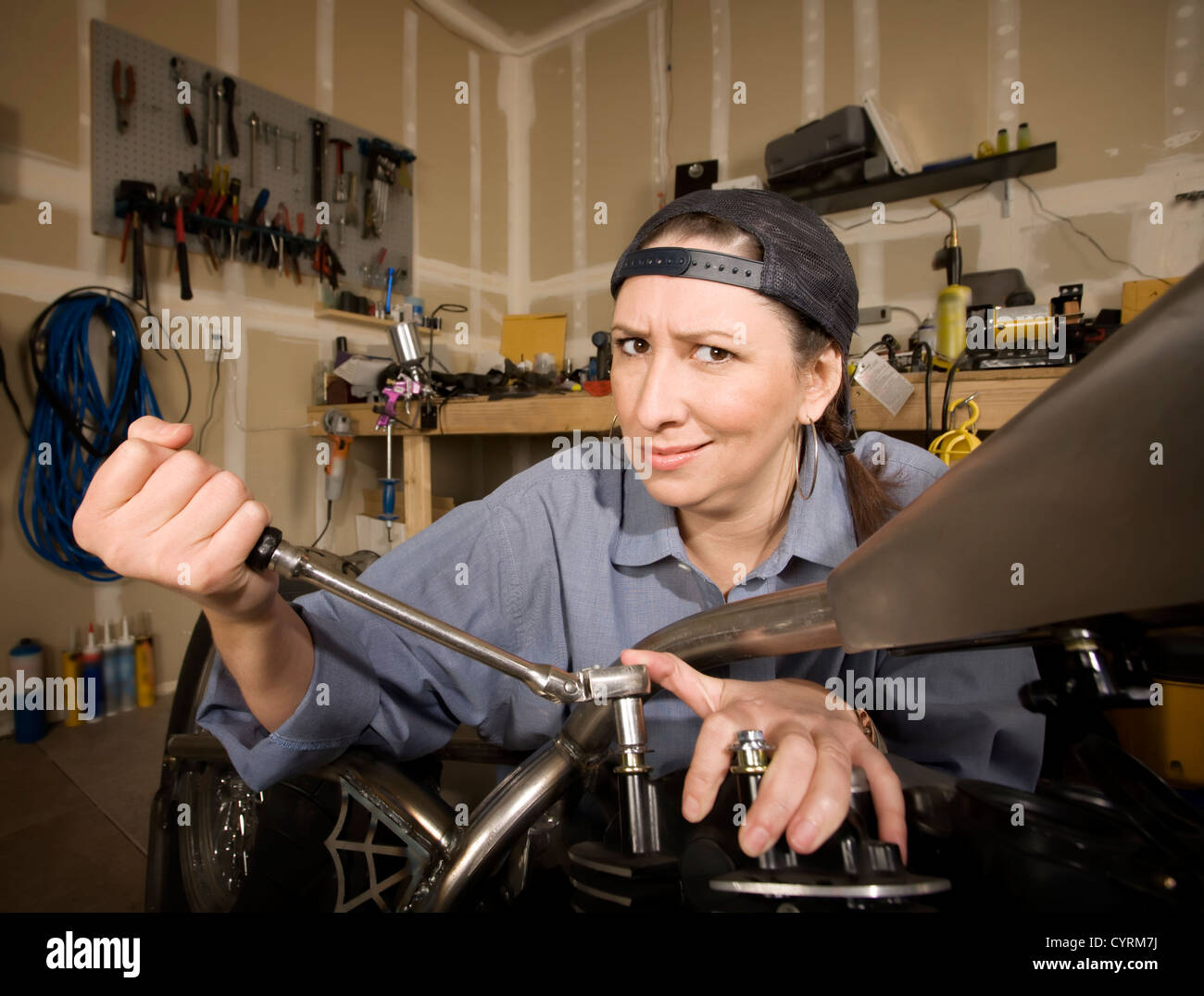 Female Hispanic mechanic working on a chopper style motorcycle Stock ...