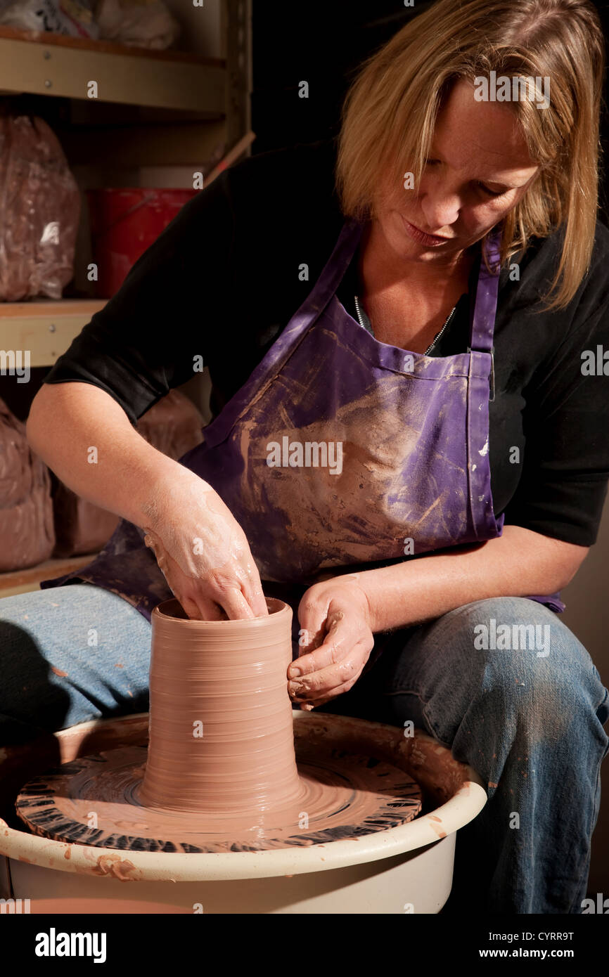 Female potter at wheel in studio shaping clay Stock Photo - Alamy